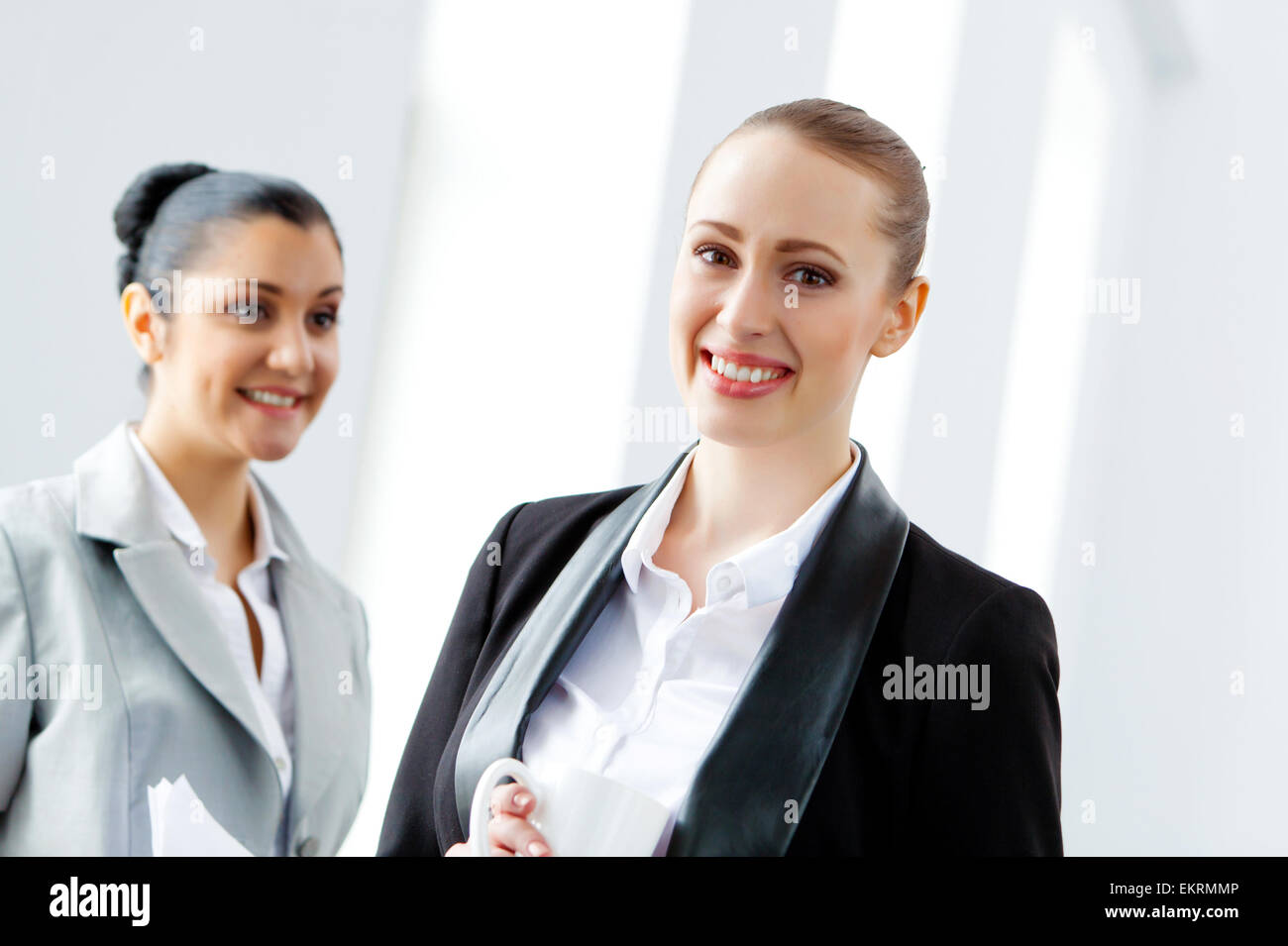 Two attractive business women smiling Stock Photo - Alamy