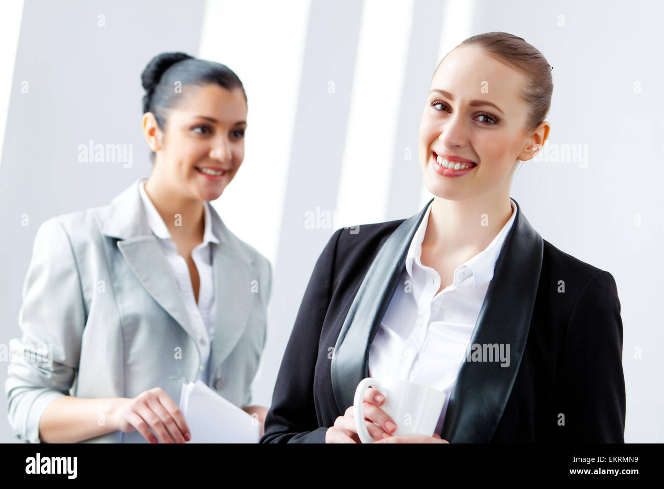 Two attractive business women smiling Stock Photo - Alamy