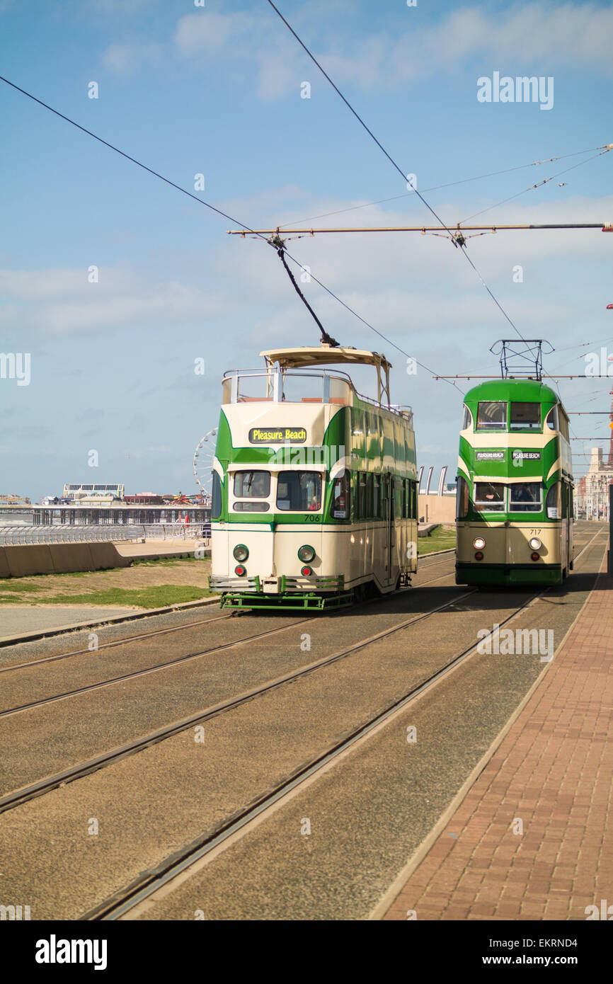 Two vintage green and cream trams pass along on the seafront tramway in ...