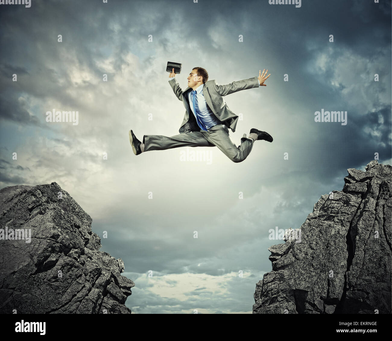 Businessman jumping over gap Stock Photo - Alamy