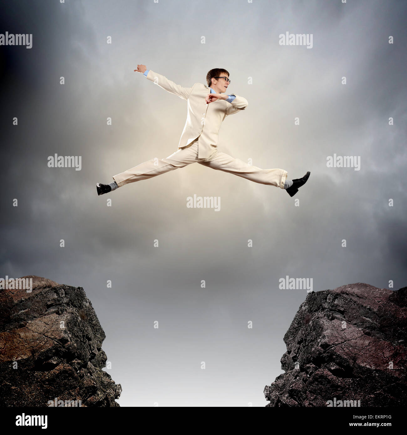 Businessman jumping over gap Stock Photo - Alamy
