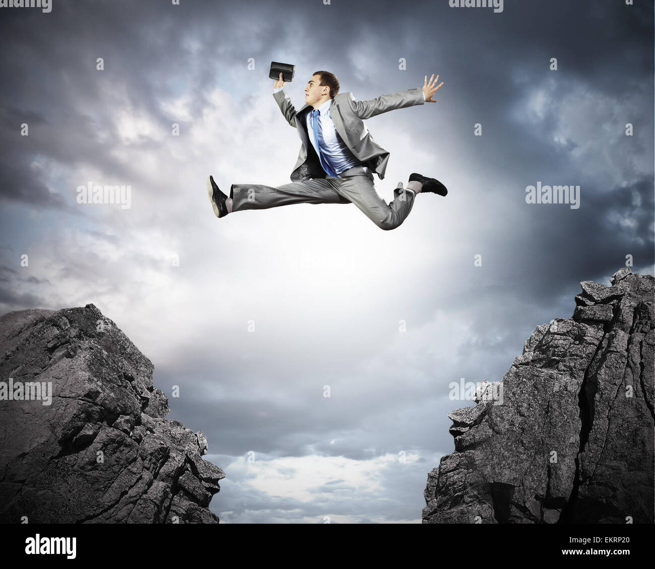 Businessman jumping over gap Stock Photo - Alamy