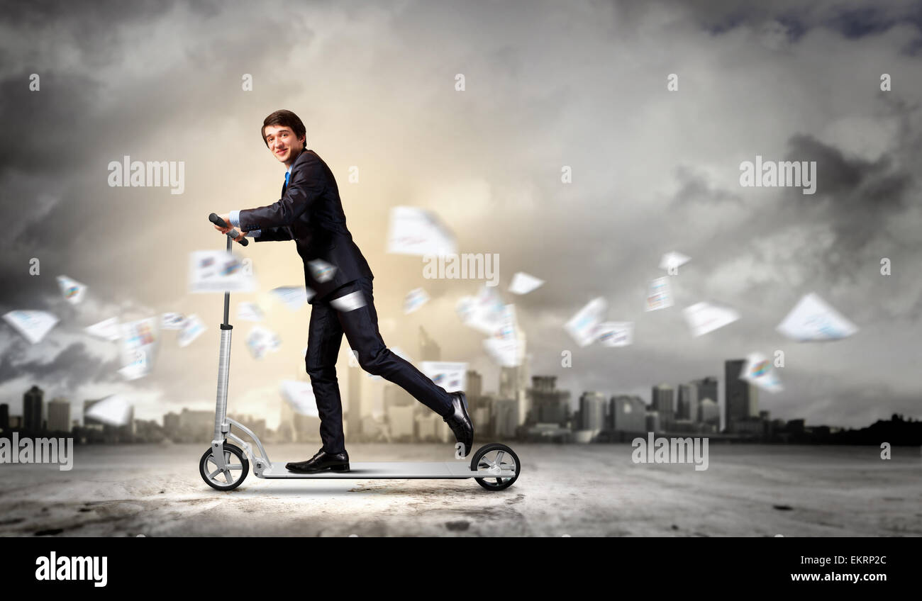 Businessman riding scooter Stock Photo - Alamy