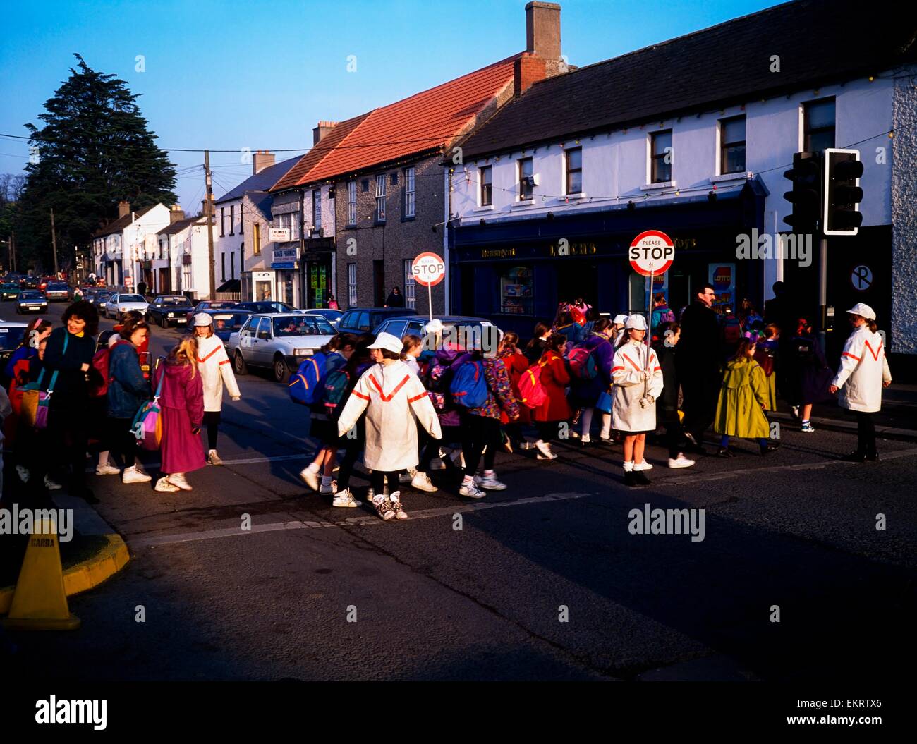 School Children Crossing The Road With The School Crossing Patrol Stock ...