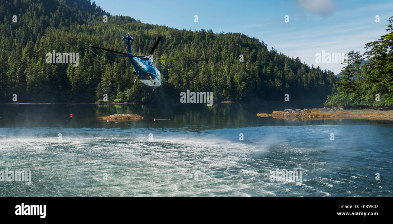 Helicopter flying over water; Queen Charlotte Islands, British Columbia ...