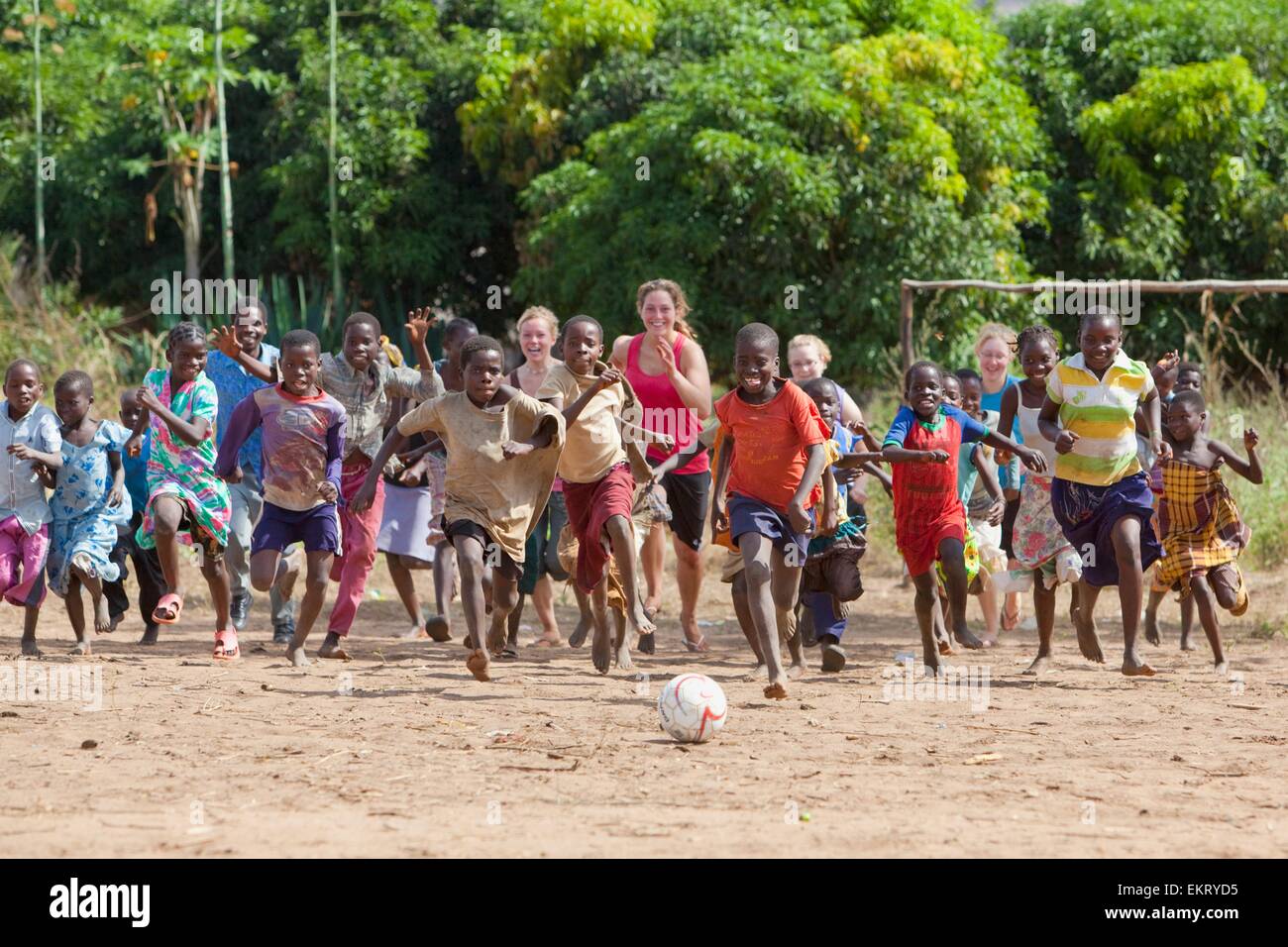A Group Of Kids Running After A Ball; Manica, Mozambique, Africa Stock ...