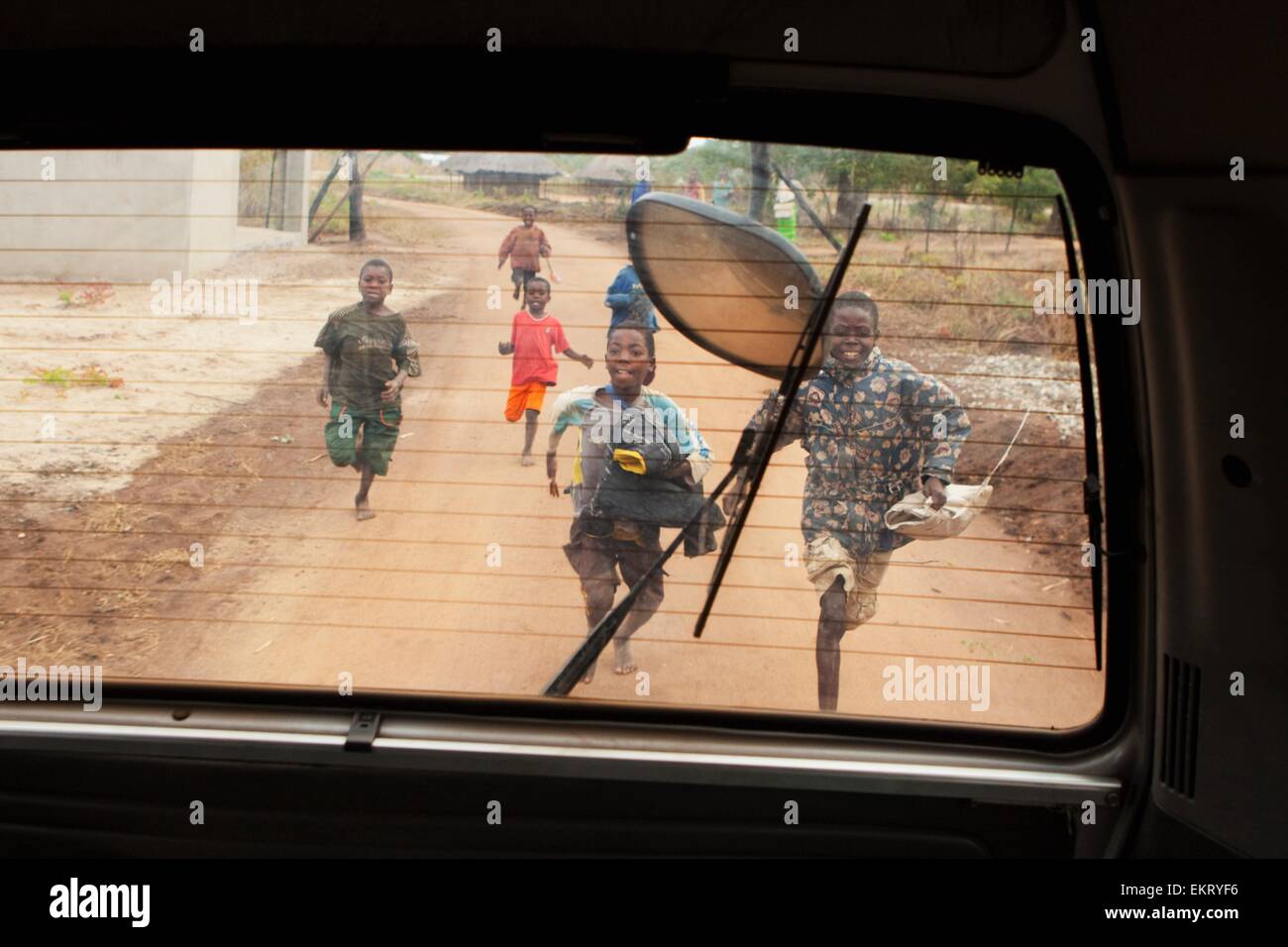 Children Running After A Moving Car As Viewed From The Back Window Of ...