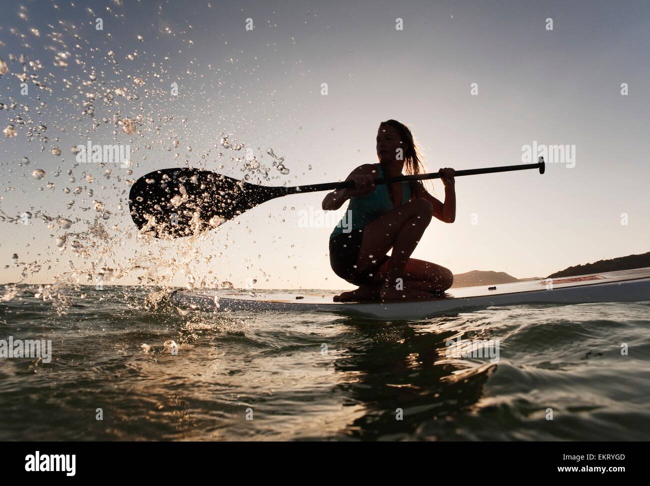 A Woman Paddling While On Her Knees On A Surf Board Off Dos Mares Beach ...