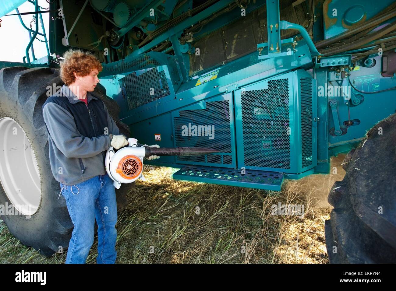 Young Farmer Cleaning Combine Tractor; Three Hills, Alberta, Canada ...