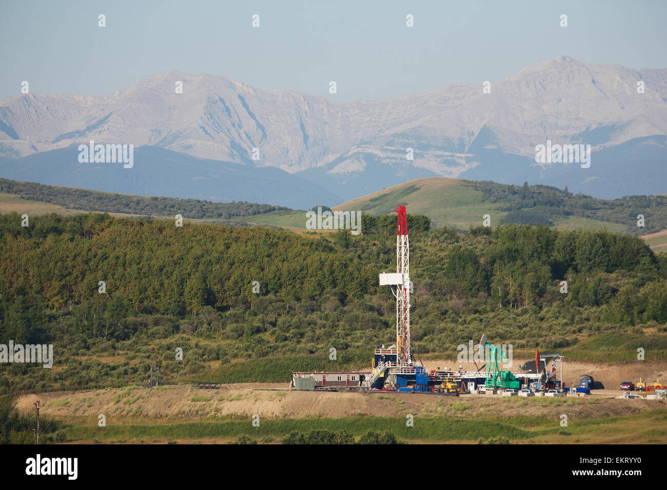 Drilling Rig With Pumpjacks In The Foothills With Mountains In The ...
