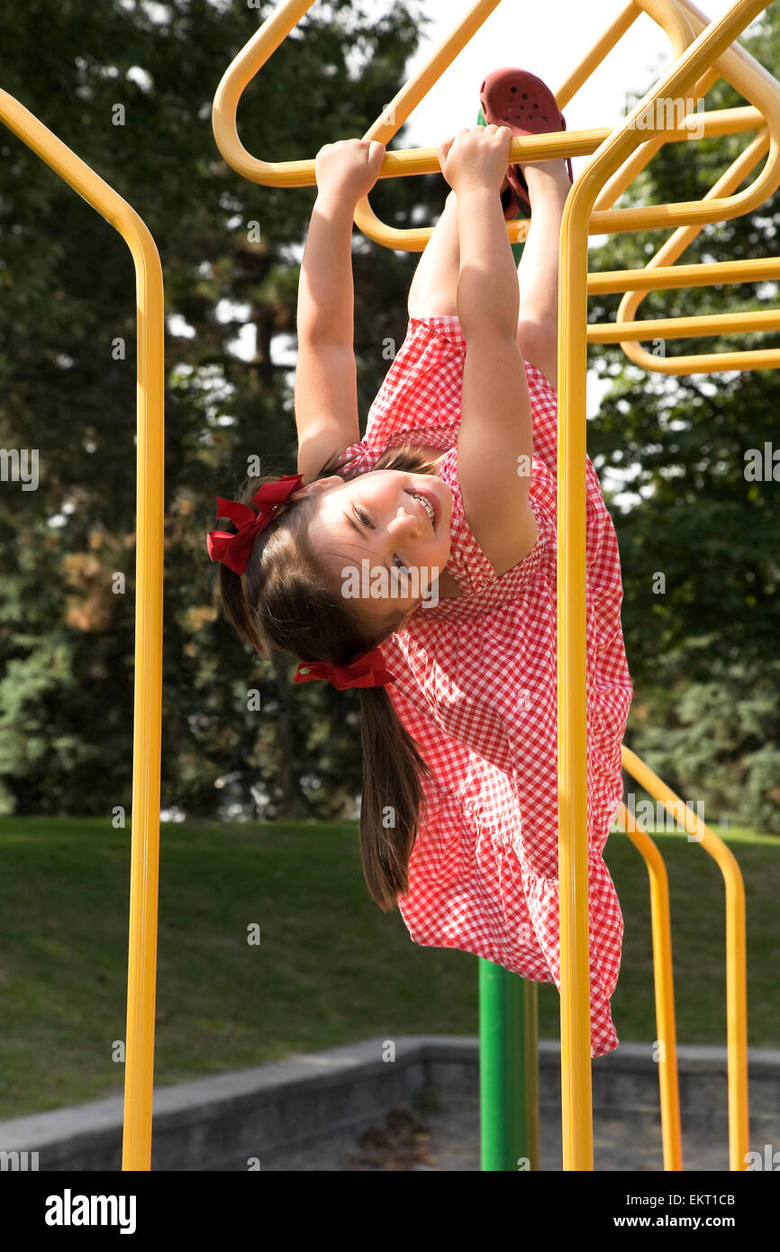 Young Asian-Caucasian Girl Hanging Upside Down On Playground Equipment; Ontario Canada Stock ...