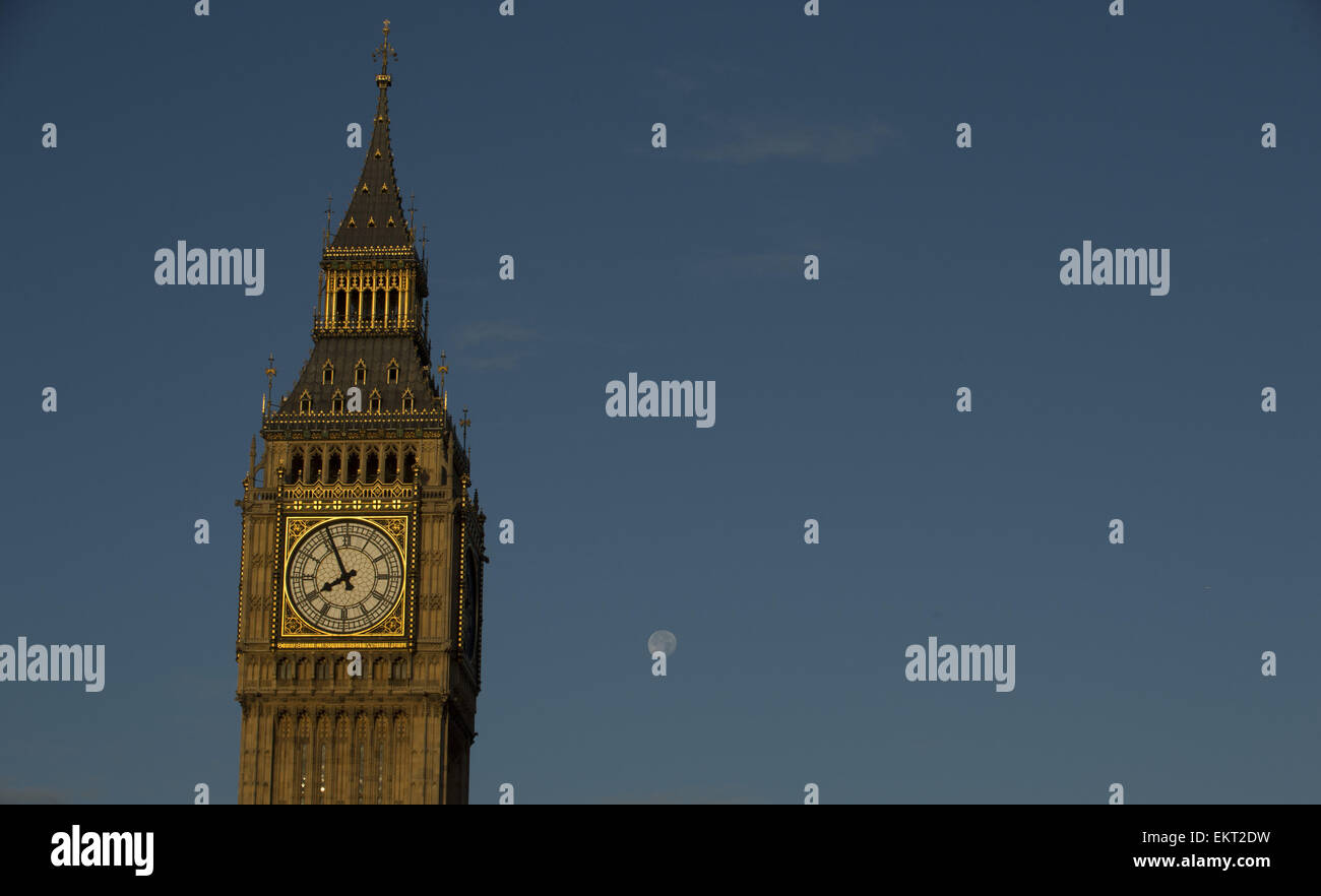 The sun rises over Big Ben in London with the moon still visible ...