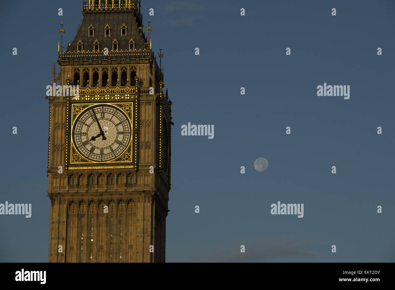 The sun rises over Big Ben in London with the moon still visible ...