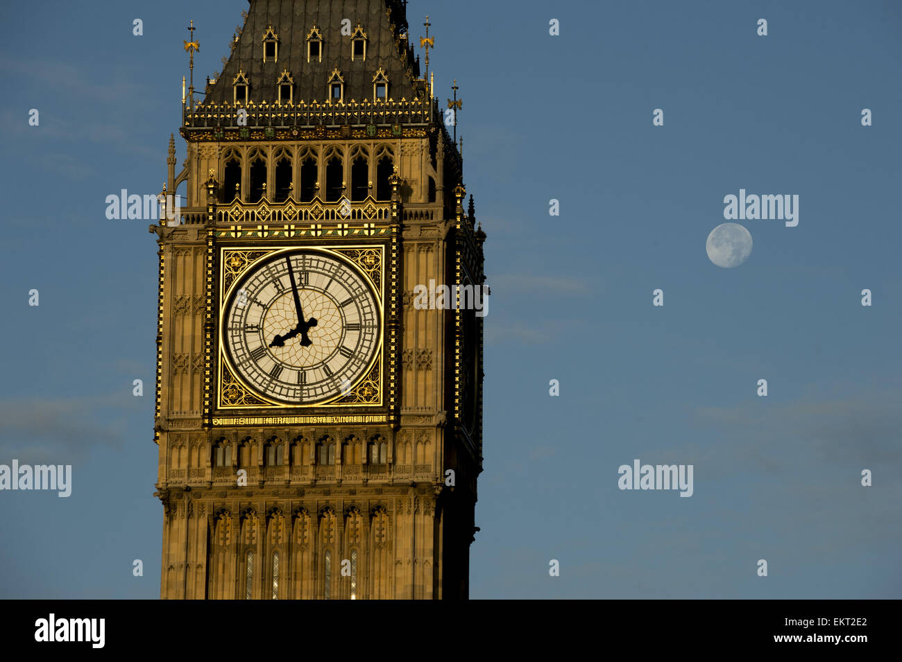 The sun rises over Big Ben in London with the moon still visible ...