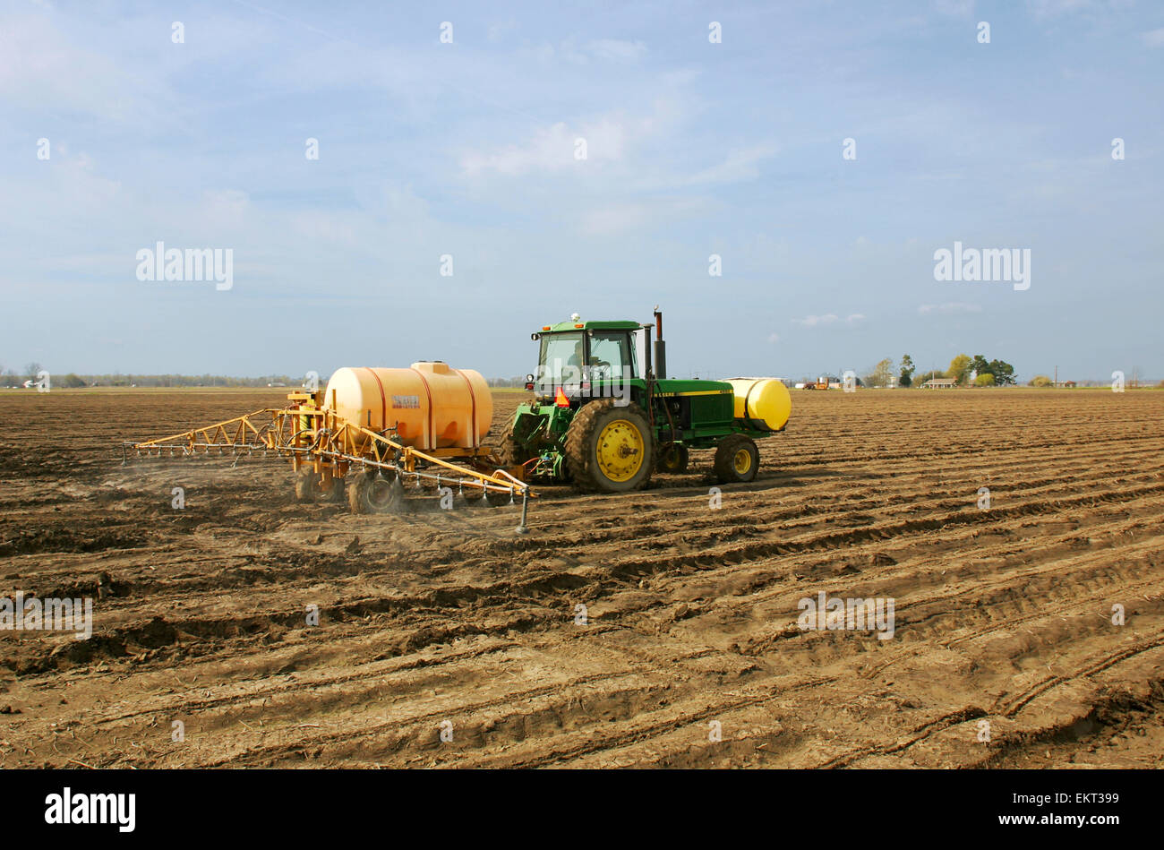A tractor equipped with a sprayer applies a pre-plant herbicide to a ...