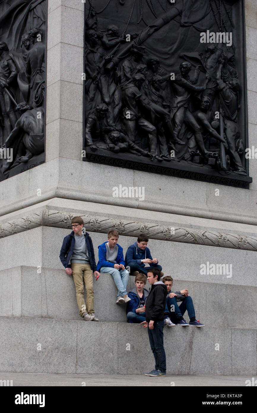Teenagers at Trafalgar Square, sit beneath the relief on the south face ...