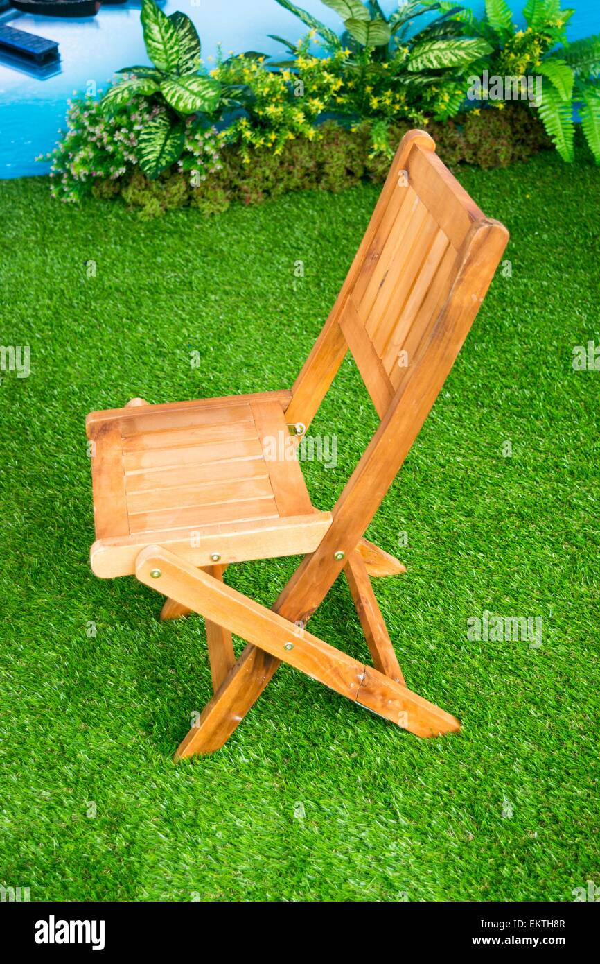 Red chair on green grass texture Stock Photo - Alamy