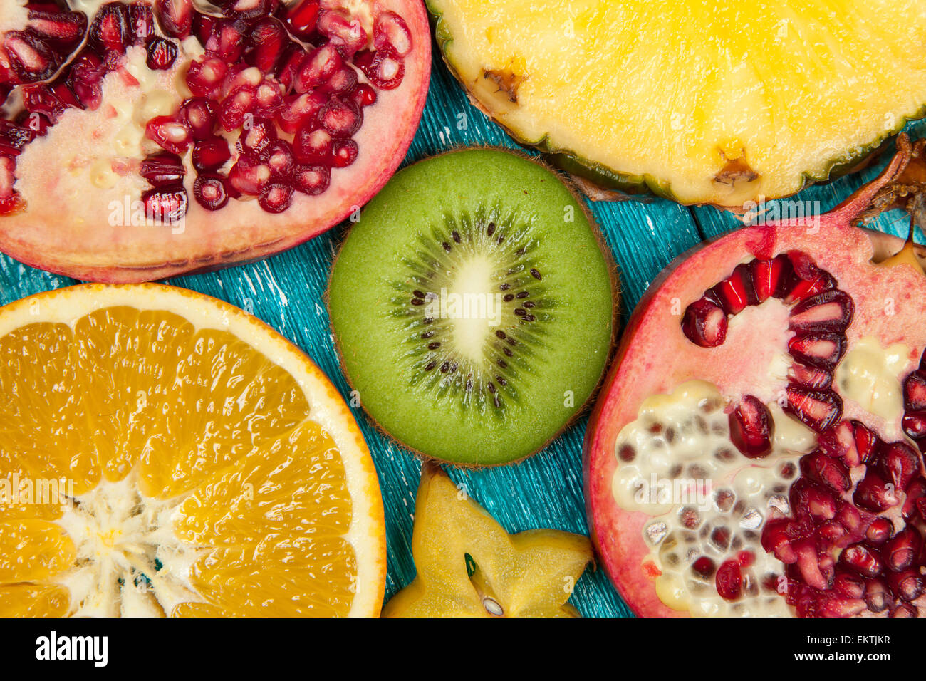 Colorful fruit slices on blue wood surface Stock Photo - Alamy