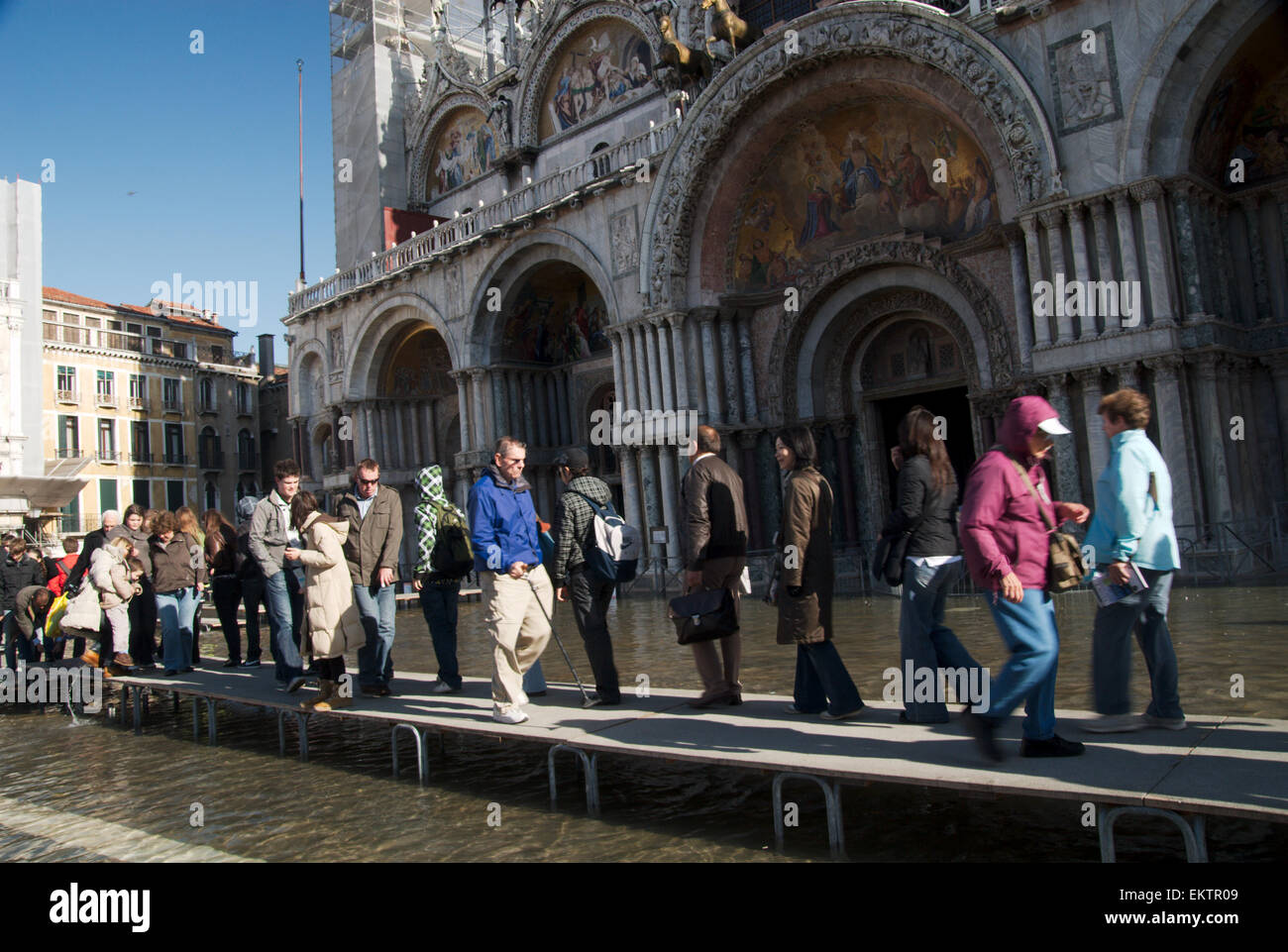 Tourists cross elevated walkways as acqua alta, the high tide floods ...