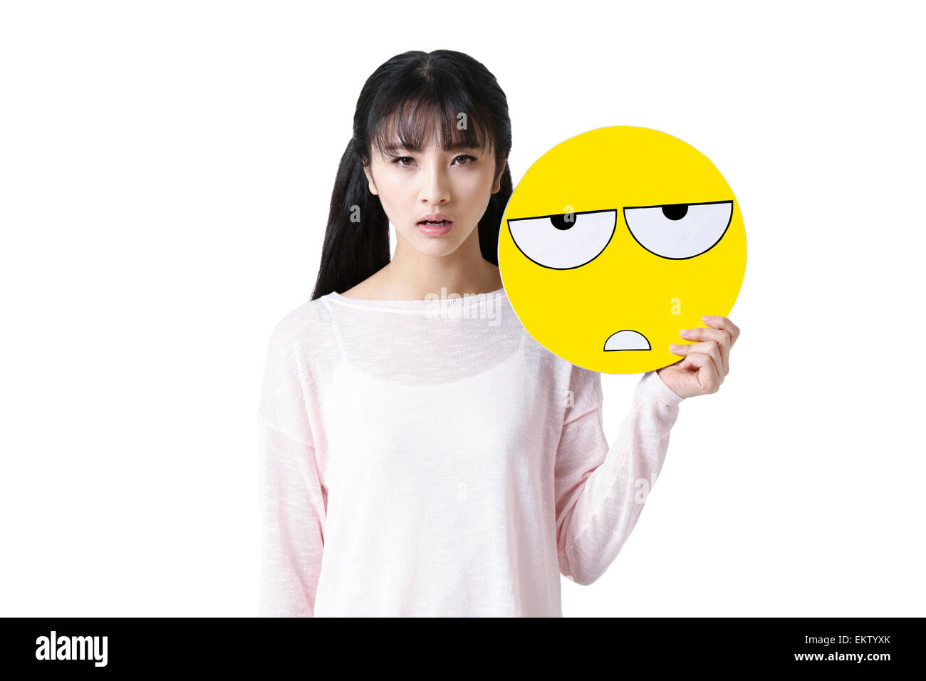 Young woman holding a tired emoticon face Stock Photo - Alamy