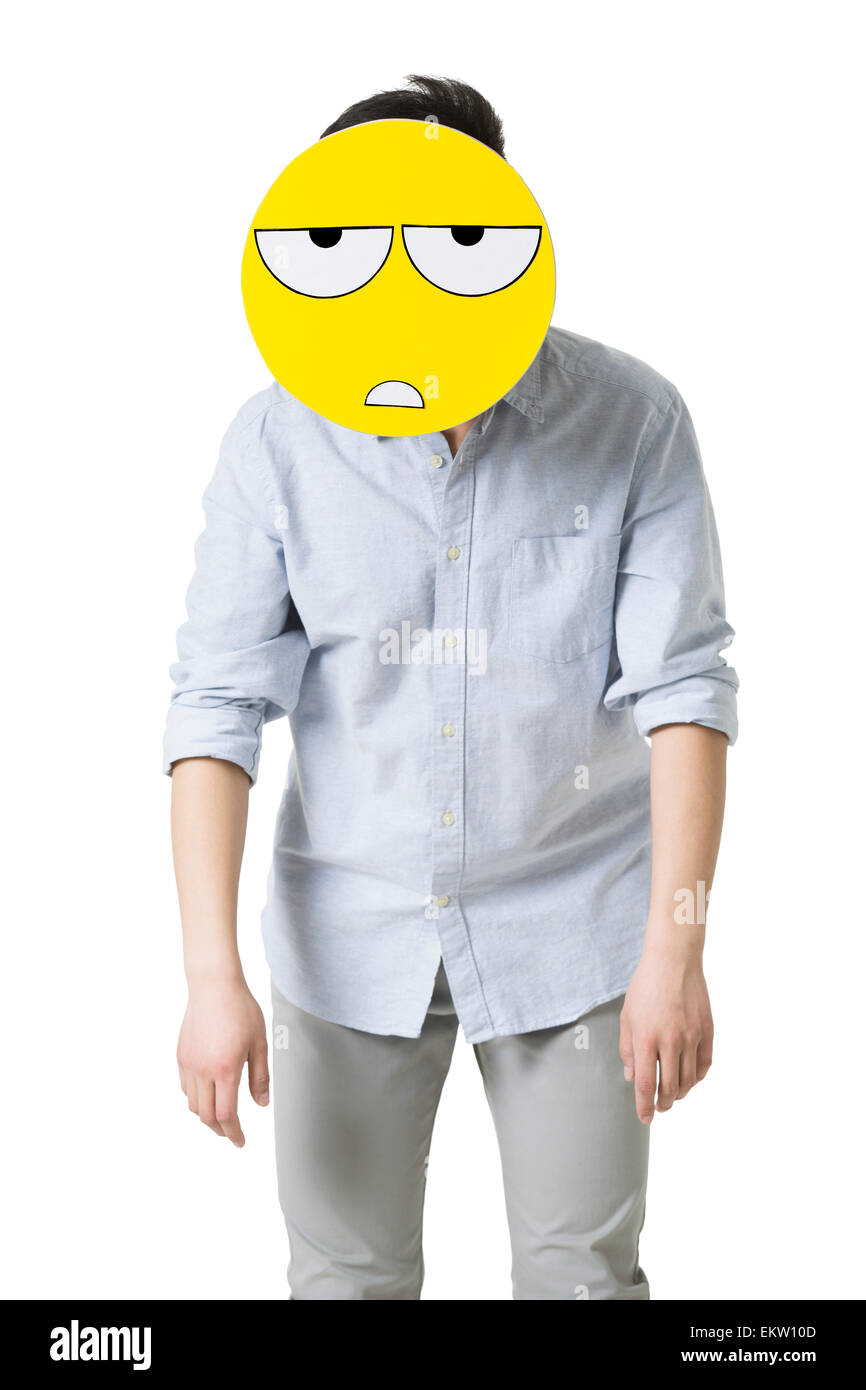 Young man with a tired emoticon face in front of his face Stock Photo ...