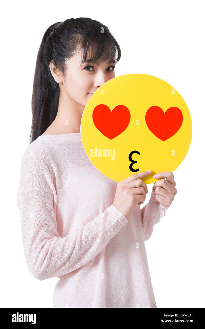 Young woman holding a romantic emoticon face Stock Photo - Alamy