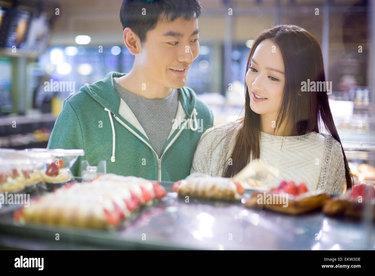 Young couple choosing cakes in bakery Stock Photo - Alamy