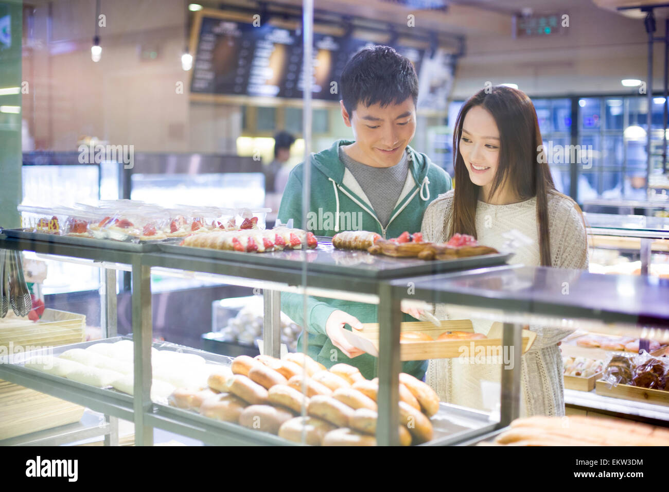 Young couple choosing cakes in bakery Stock Photo - Alamy