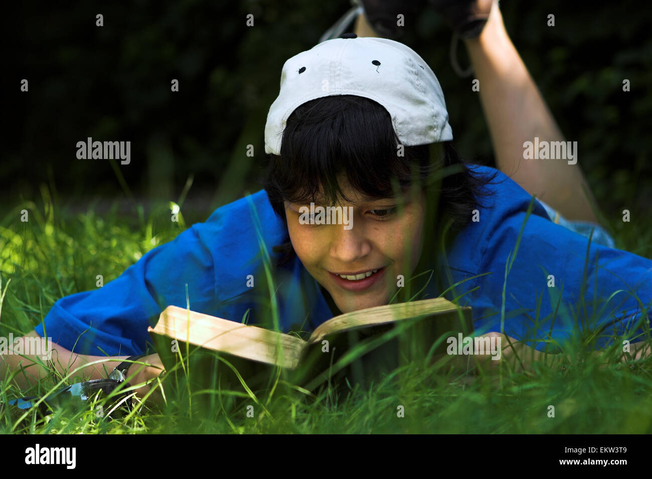 Boy reading in the park on a sunny day Stock Photo - Alamy