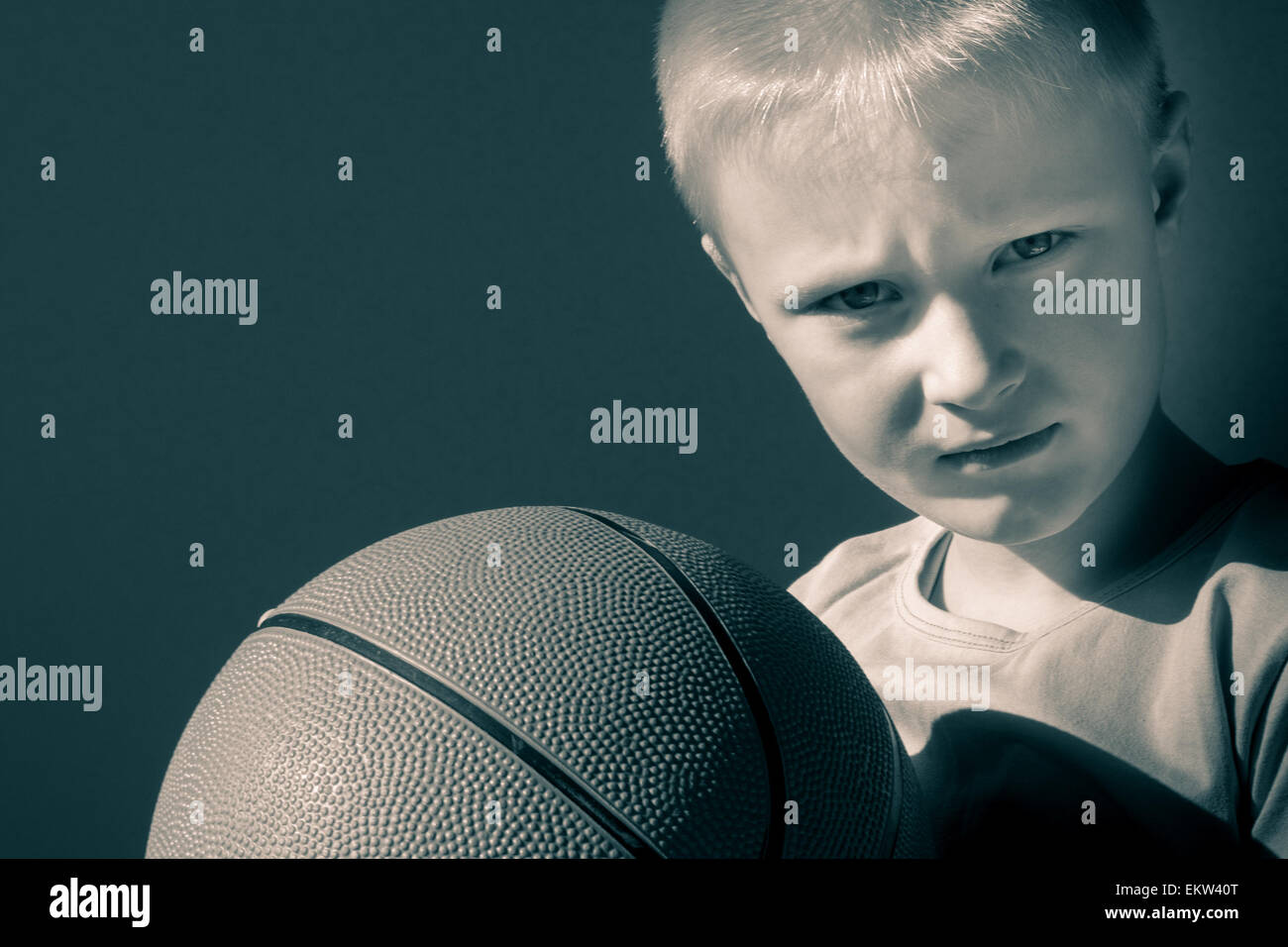 Upset little child (boy) with basketball, close up horizontal portrait ...