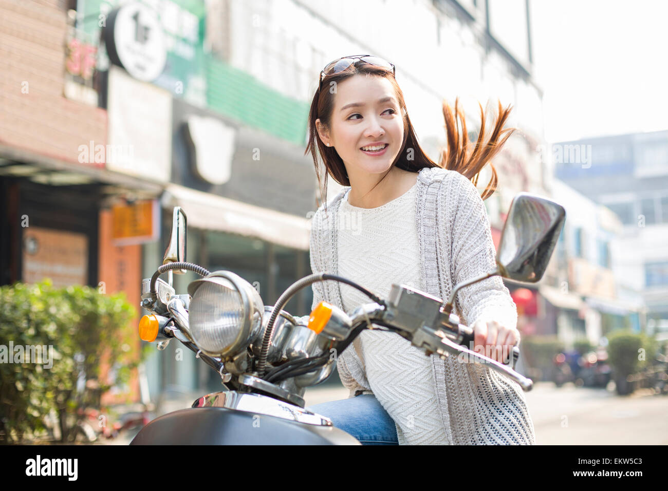 Young woman riding motorcycle Stock Photo - Alamy