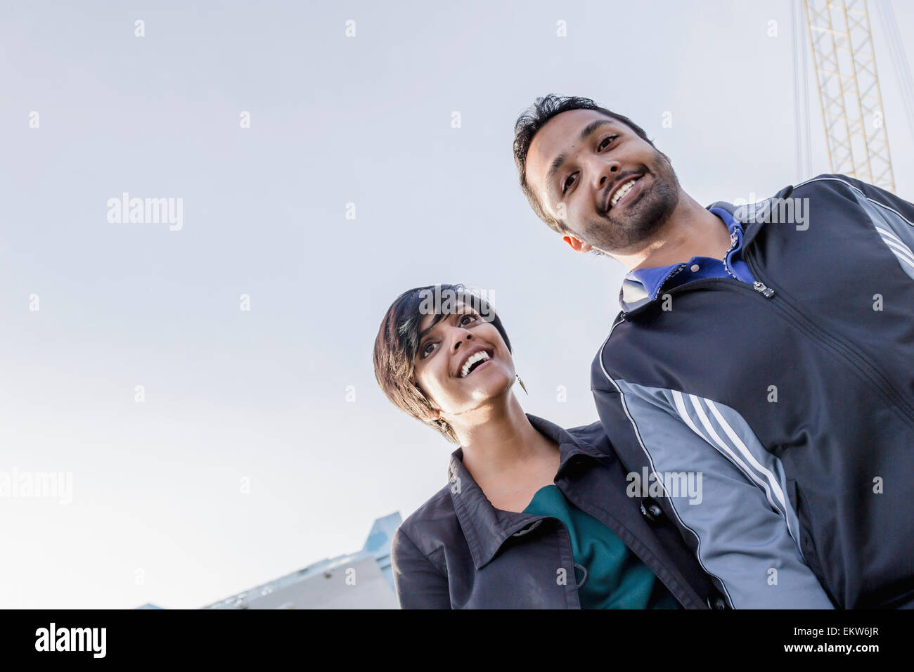 A young Indian ethnicity couple walking together smiling and laughing ...