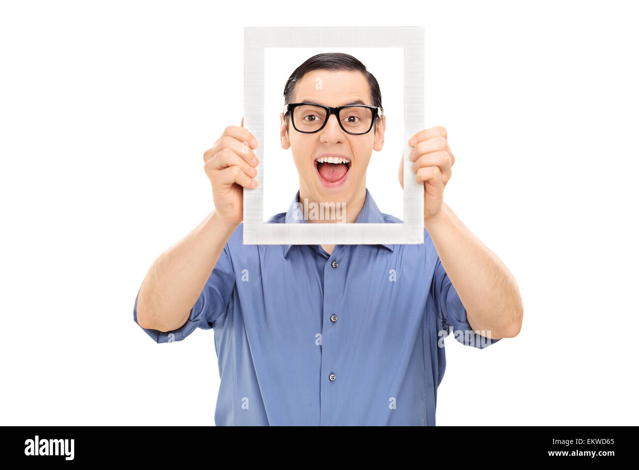 An excited young guy with glasses, posing behind a white picture frame ...