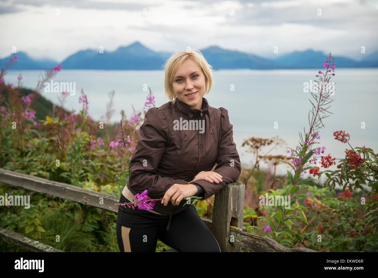 Woman stands on hillside overlooking Cook Inlet near Homer, Kenai ...