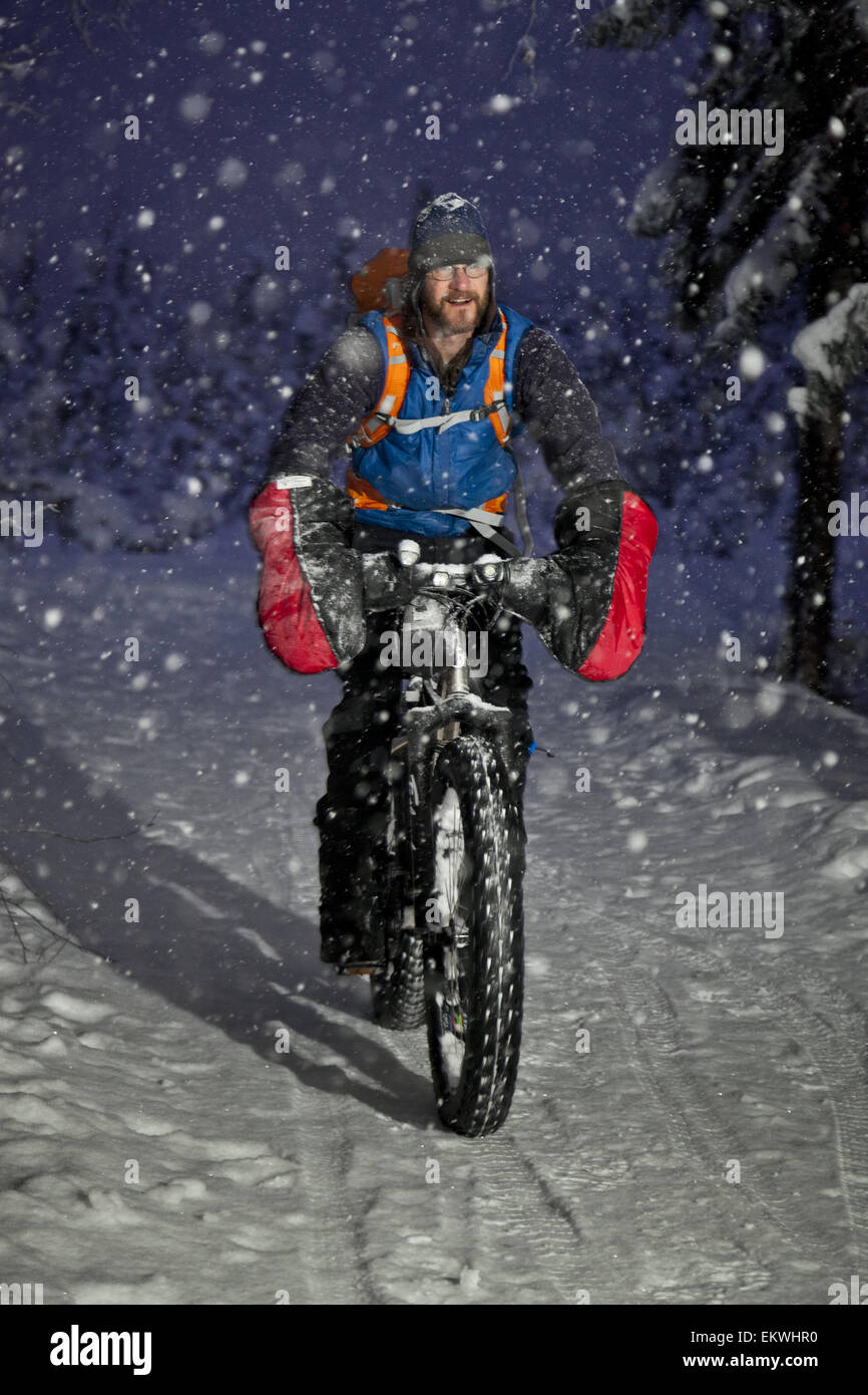 Winter cyclist riding his fatbike on the Chester Creek trail in ...