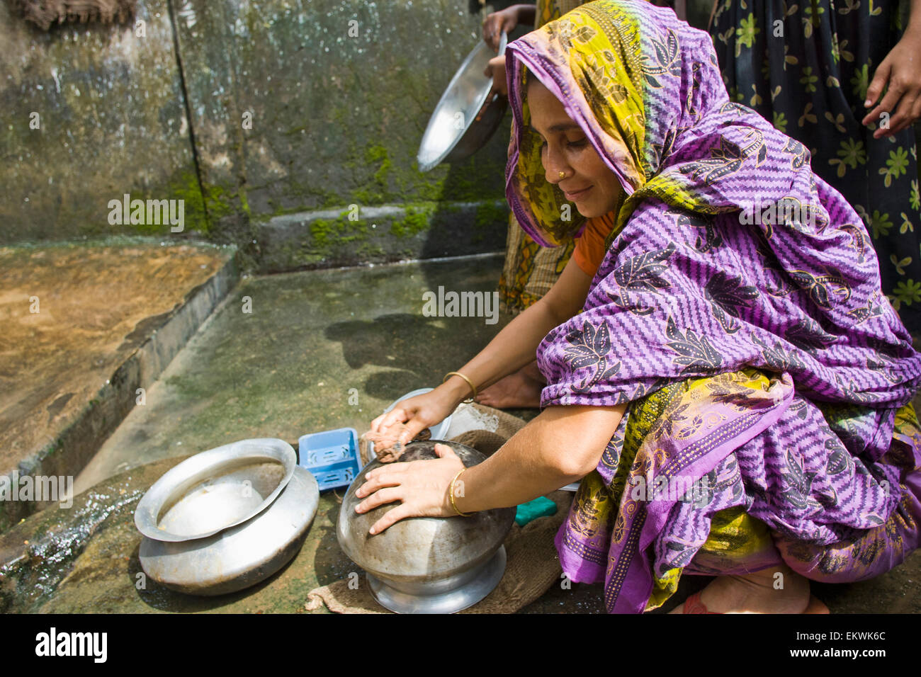 A Woman Preparing Food On The Ground In The Slums; Sylhet, Bangladesh ...