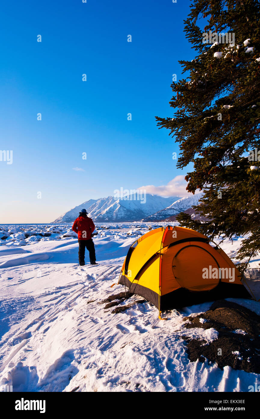 A man at his winter campsite on Bird Point with Turnagain Arm in the ...