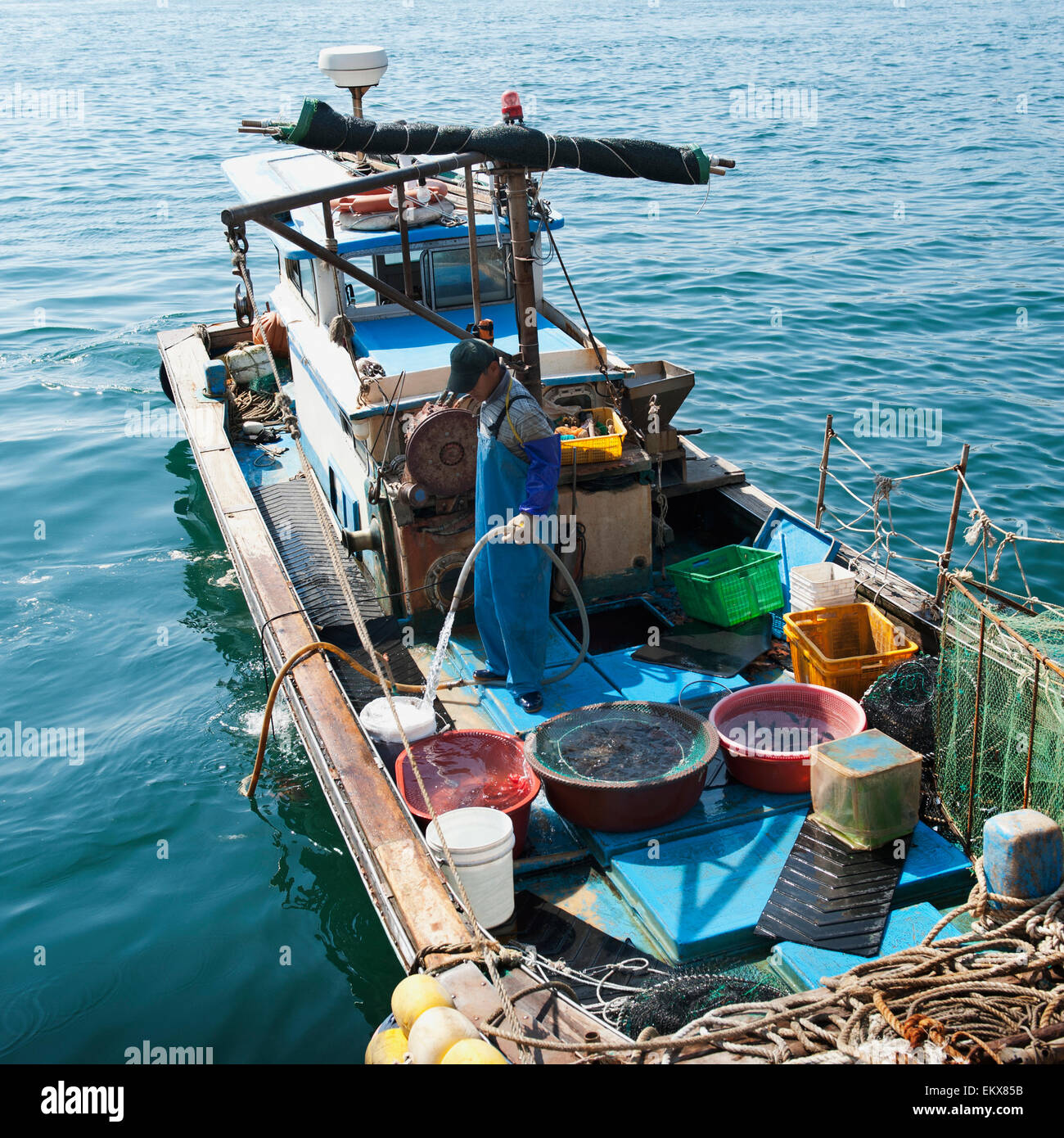 A Fisherman Stands On A Fishing Boat In The Water; Busan Korea Stock ...