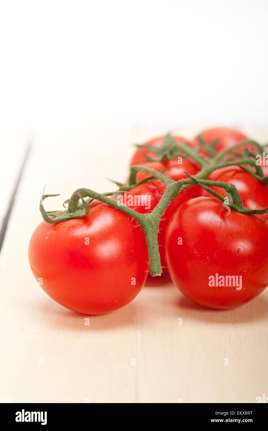fresh cherry tomatoes on a cluster over rustic wood table Stock Photo ...