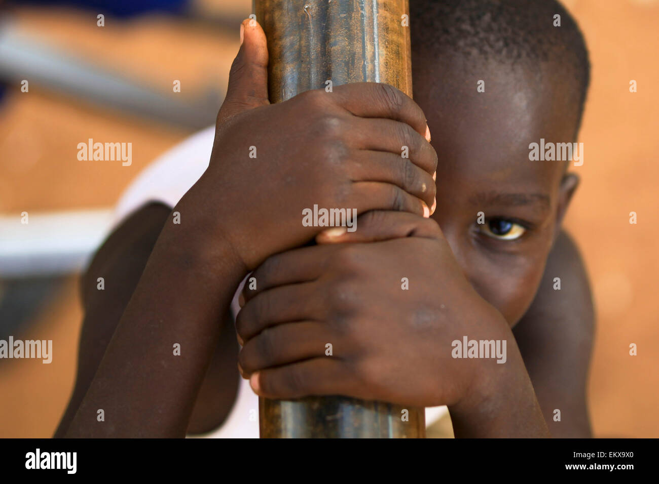 A Boy Hiding Behind A Pole; Kampala Uganda Africa Stock Photo - Alamy