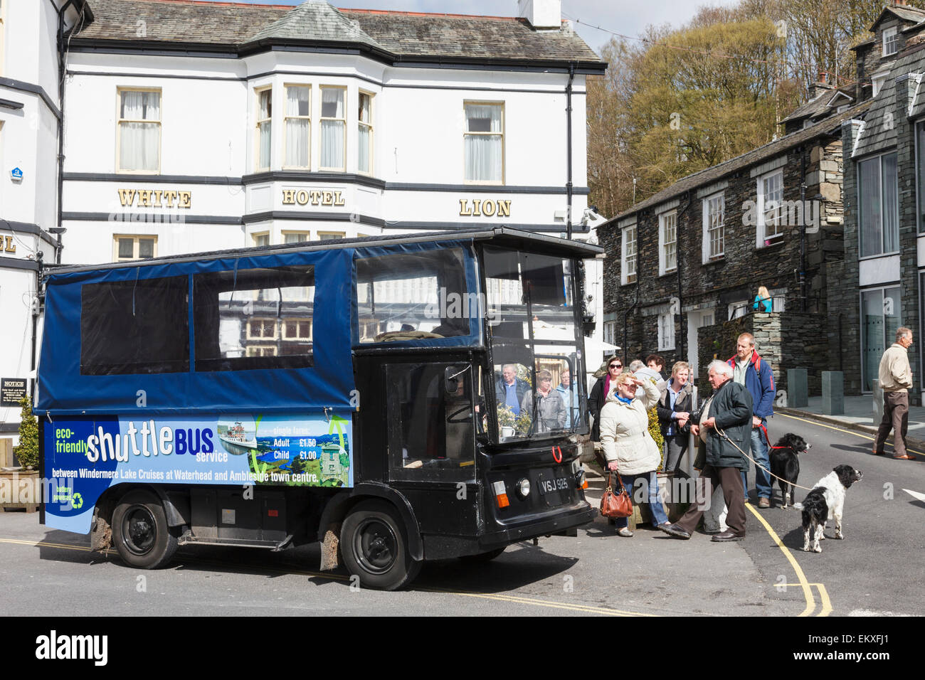 Tourists waiting by battery powered eco-friendly shuttle bus service ...