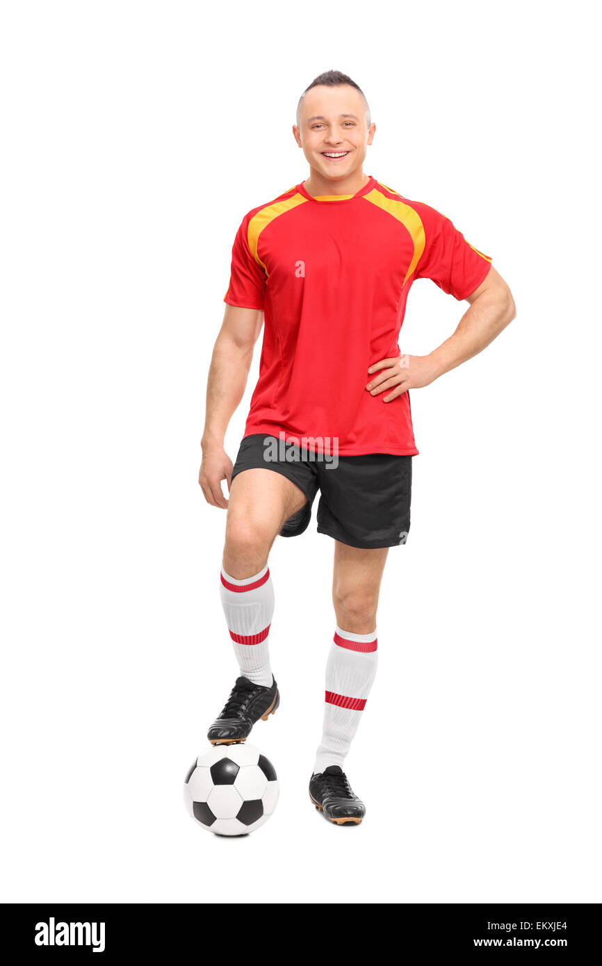 Full length portrait of a young male soccer player standing over a ball ...