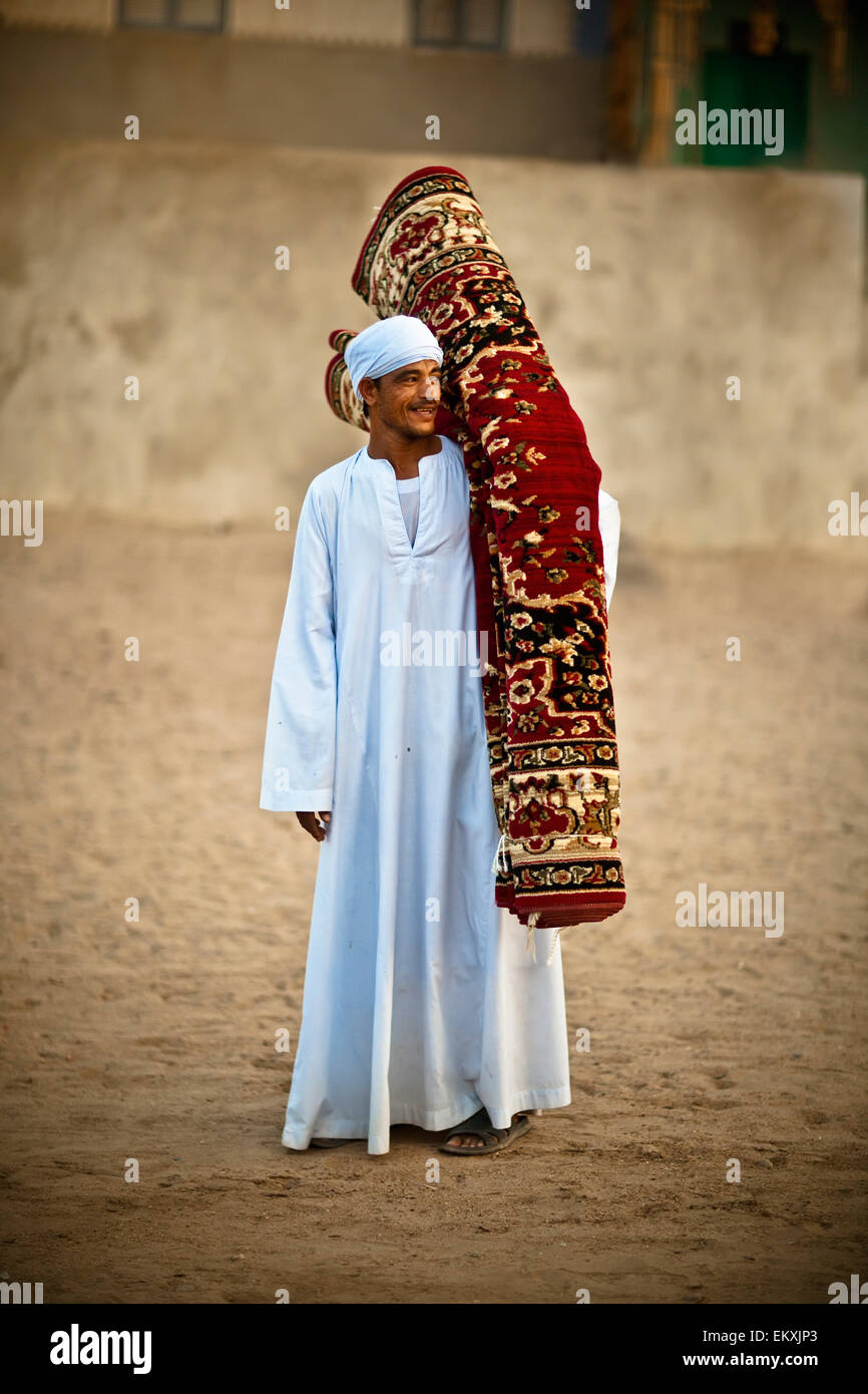 A Muslim Man Carrying A Rolled Persian Rug; Nubia Egypt Stock Photo - Alamy
