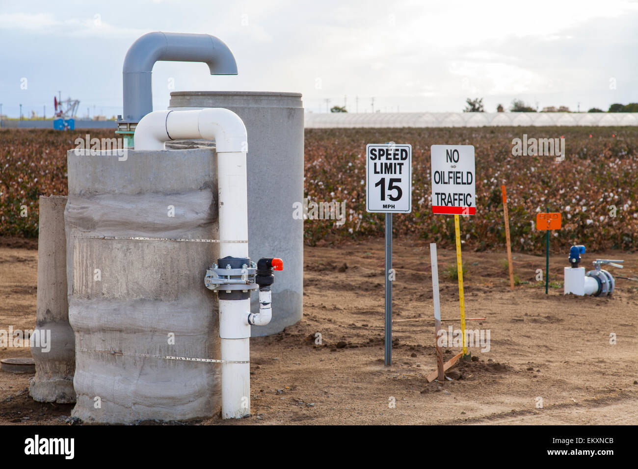 No oilfield traffic sign next to groundwater well with oil well ...