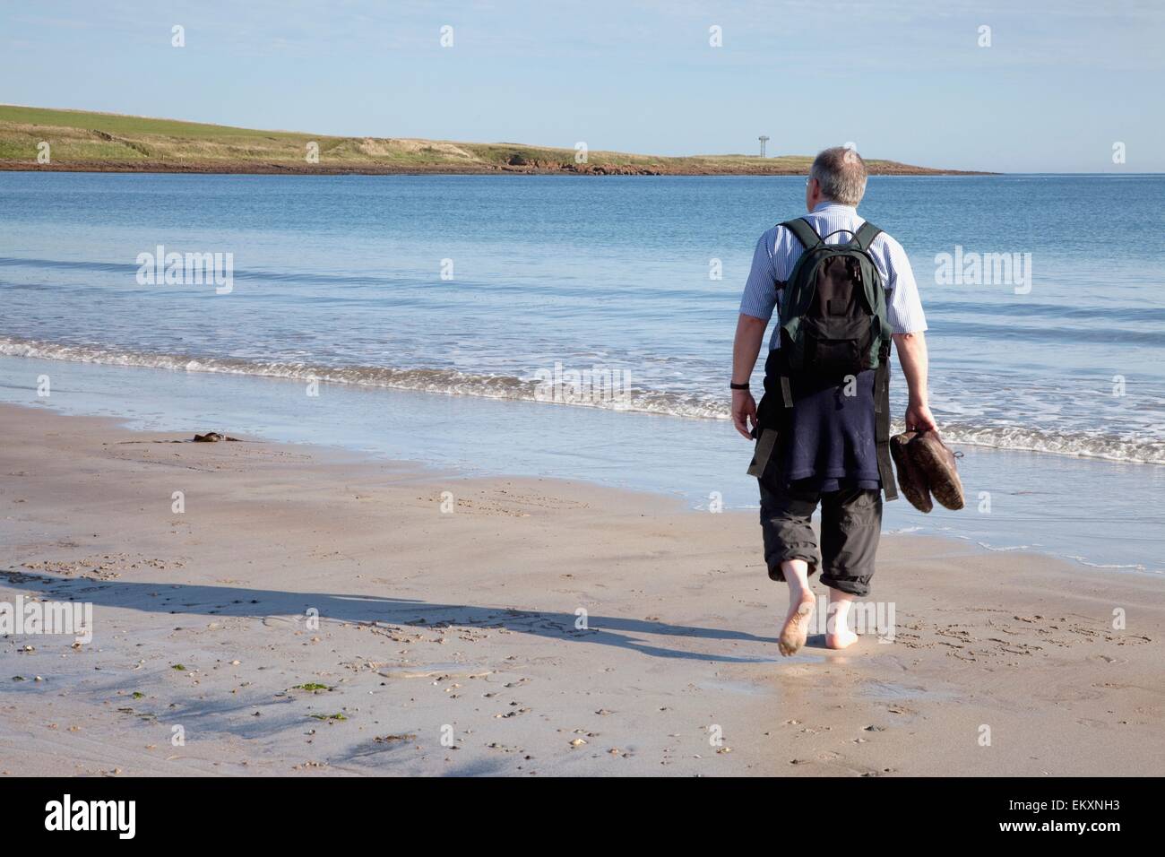 Man Walking On The Beach; Northumberland, England Stock Photo - Alamy