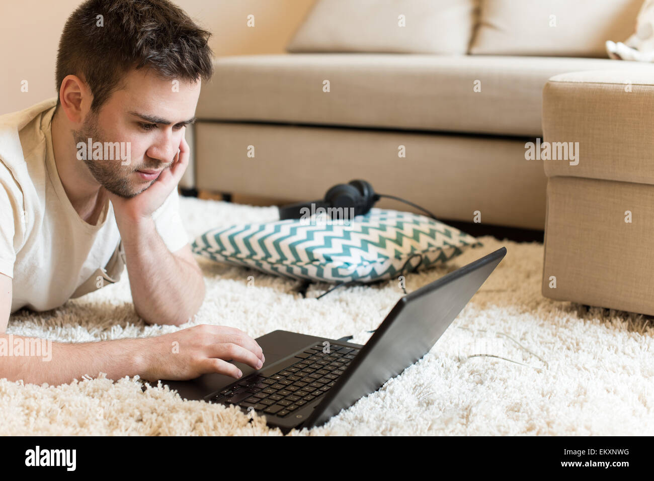 Man lying on the floor typing on laptop Stock Photo - Alamy