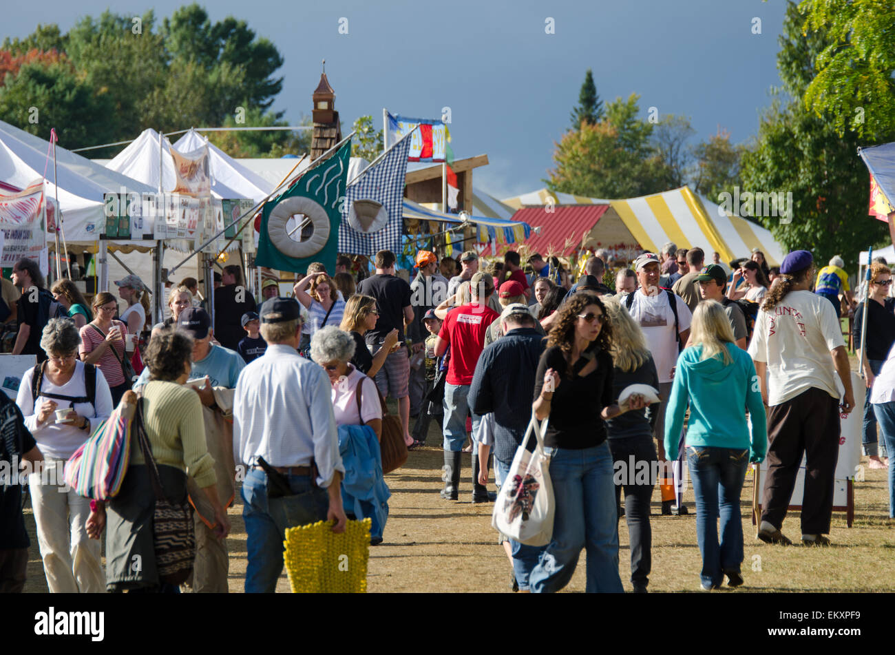 Crowds wander past food tents as storm clouds gather above at the ...