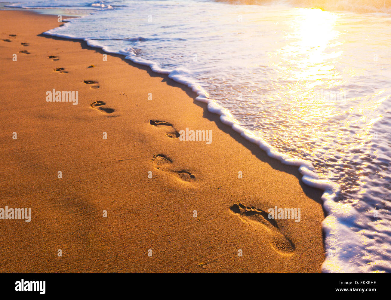 beach, wave and footsteps at sunset time Stock Photo - Alamy