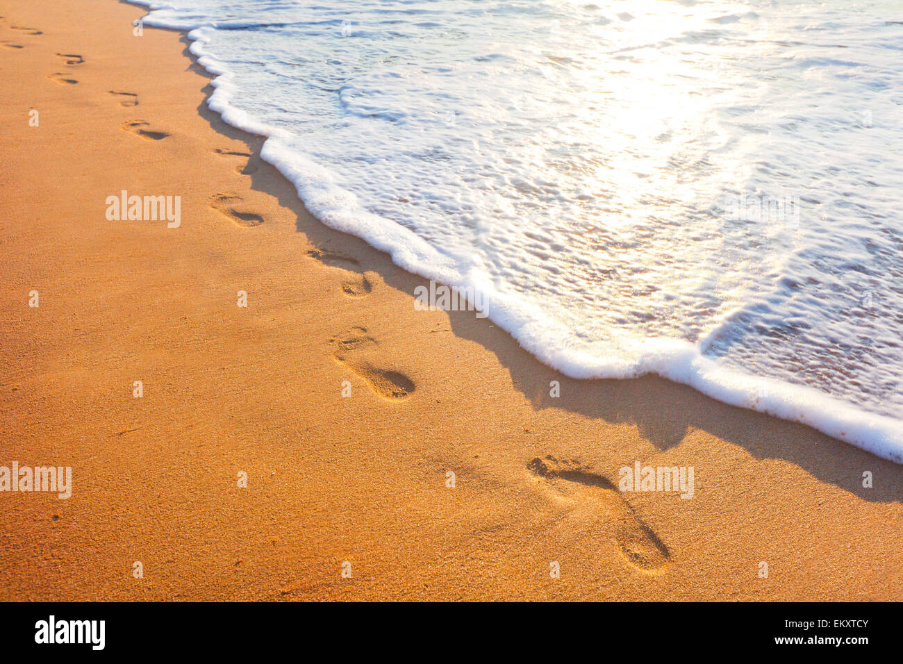 beach, wave and footsteps at sunset time Stock Photo - Alamy