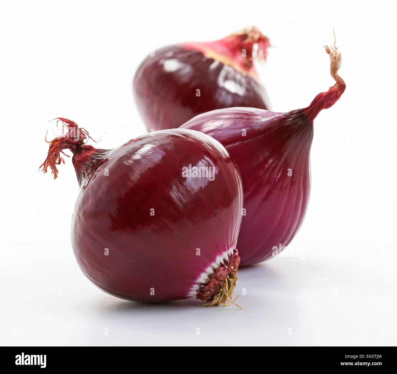 Three shiny red onions (allium) isolated on white background Stock ...